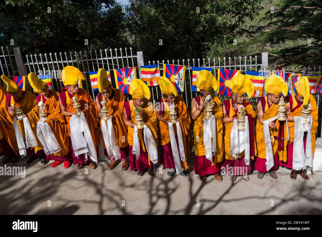 Exile Tibetan Buddhist monks in yellow ceremonial hats wait to welcome ...