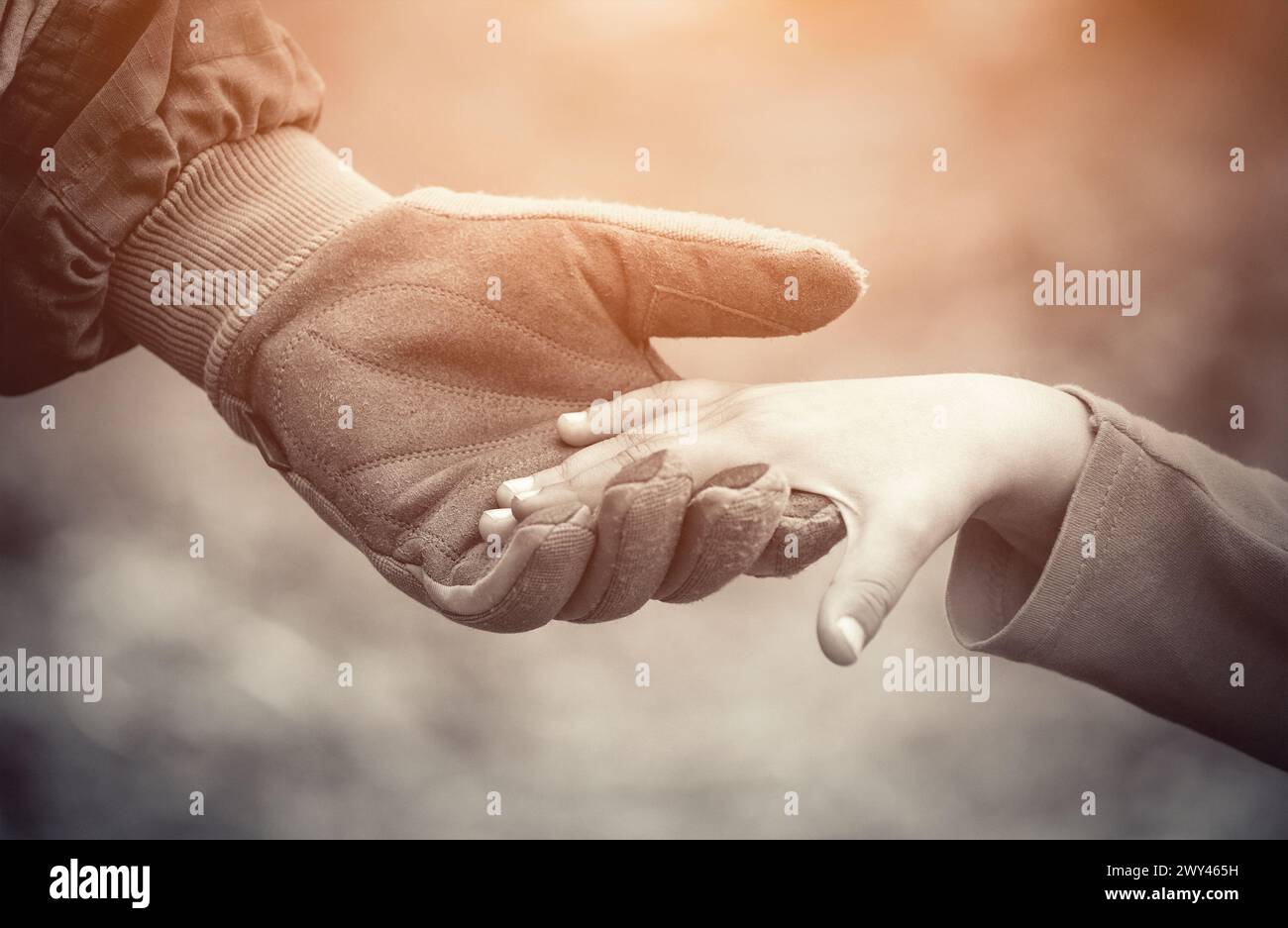 A soldier in the army uniform and gloves, holding out his hand a little ...