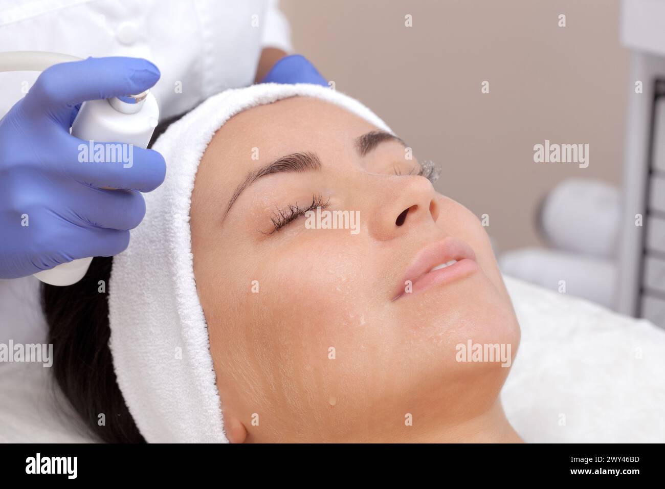 The procedure of steaming the skin of the face of a young woman before ...
