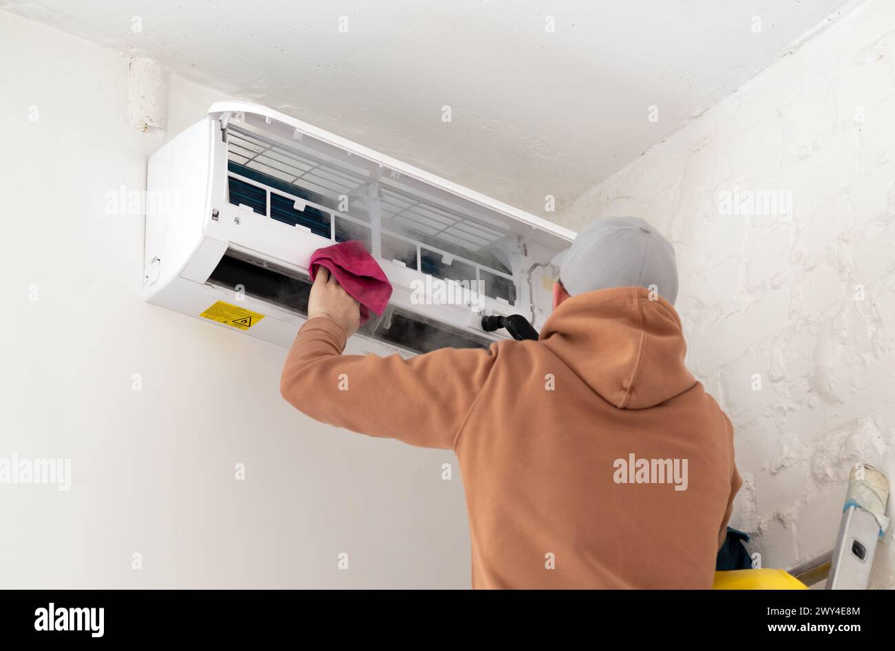Technician service using vacuum cleaner to cleaning the air conditioner ...
