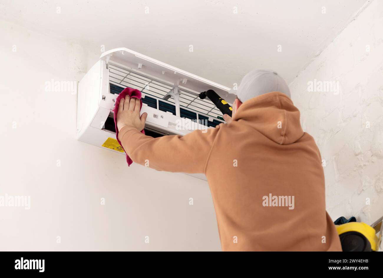 Technician service using vacuum cleaner to cleaning the air conditioner ...