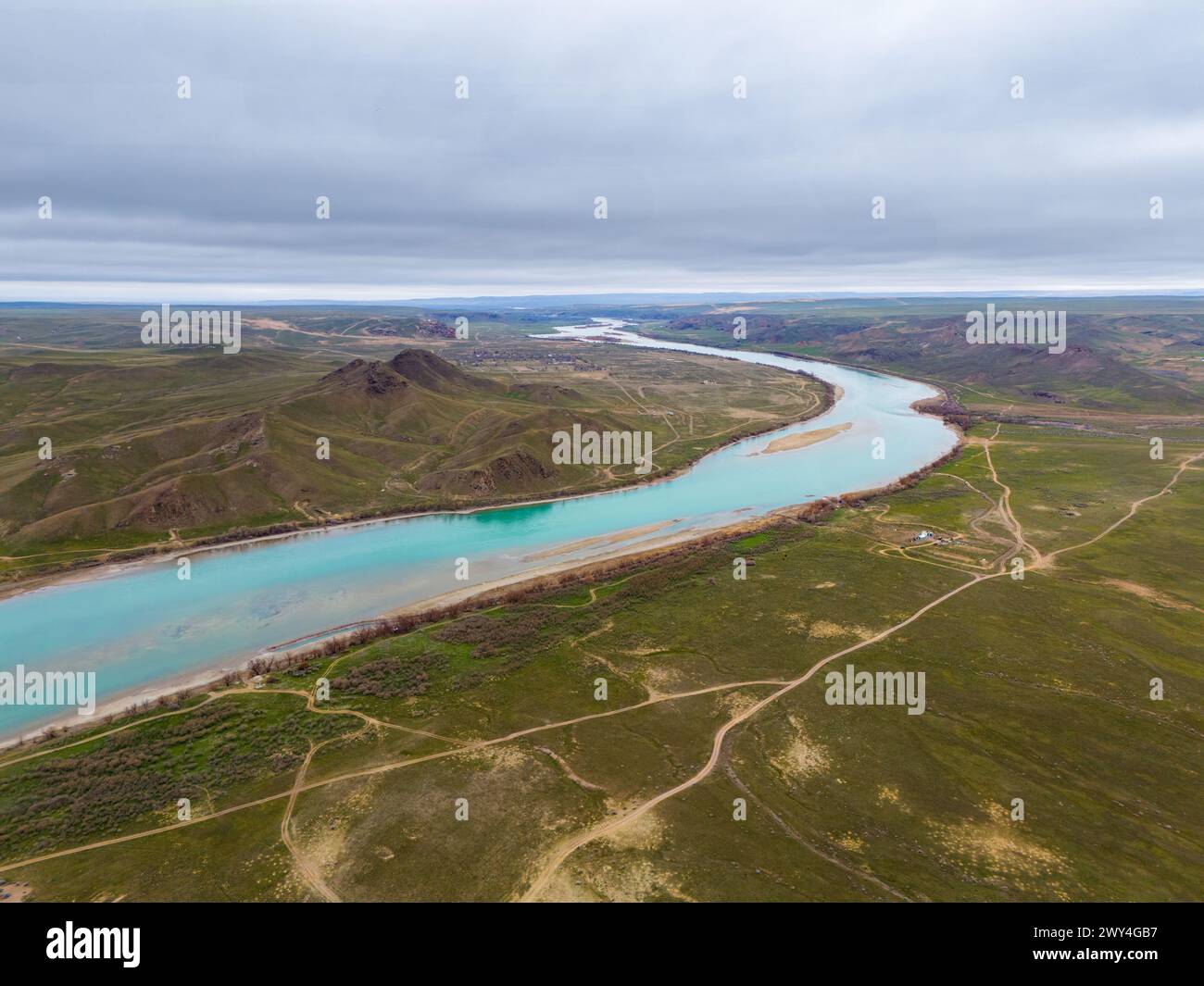An aerial view of the Ili River in early spring on a cloudy day. The ...