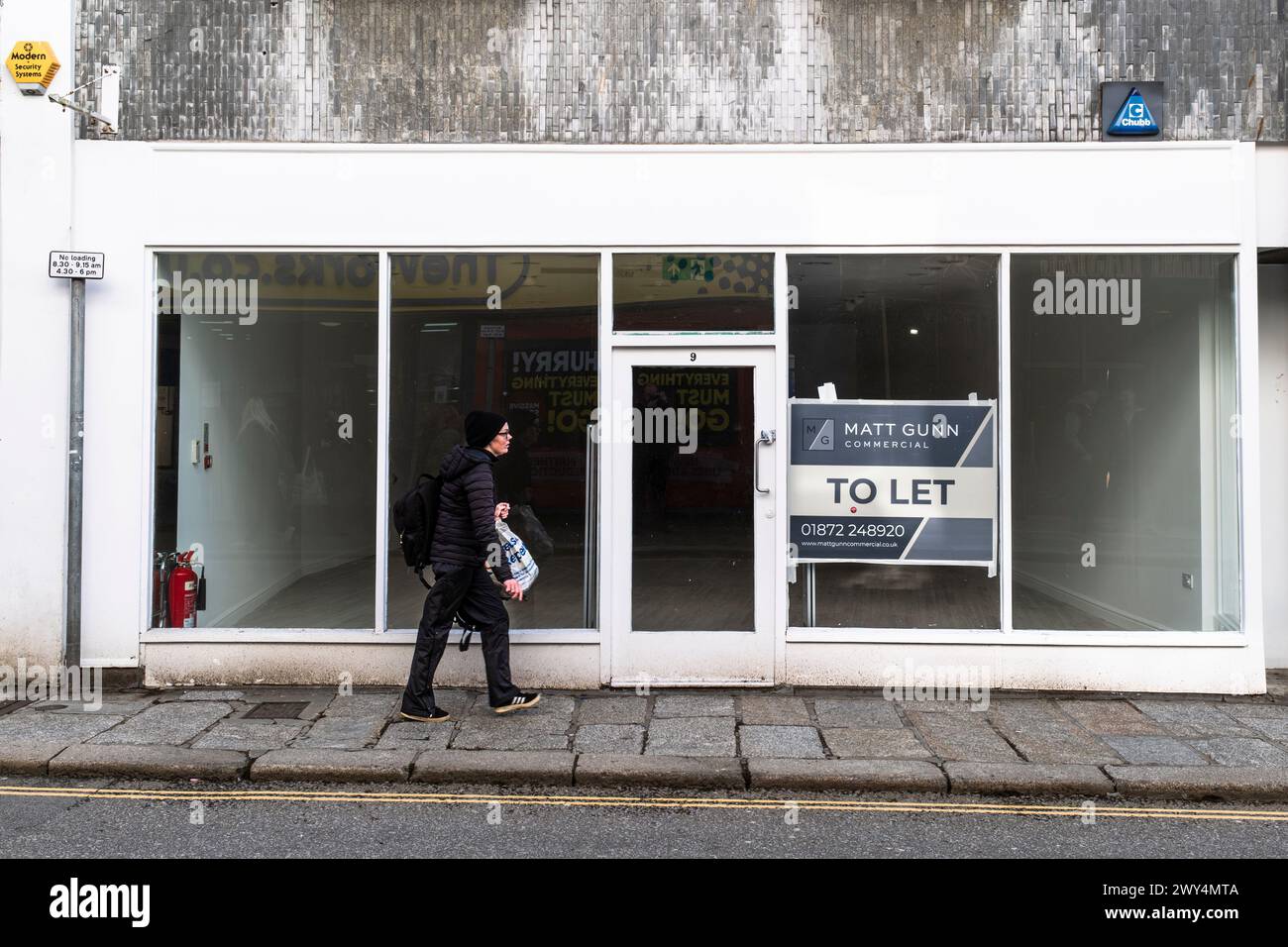 A pedestrian walking past a closed empty shop store St Nicholas Street ...