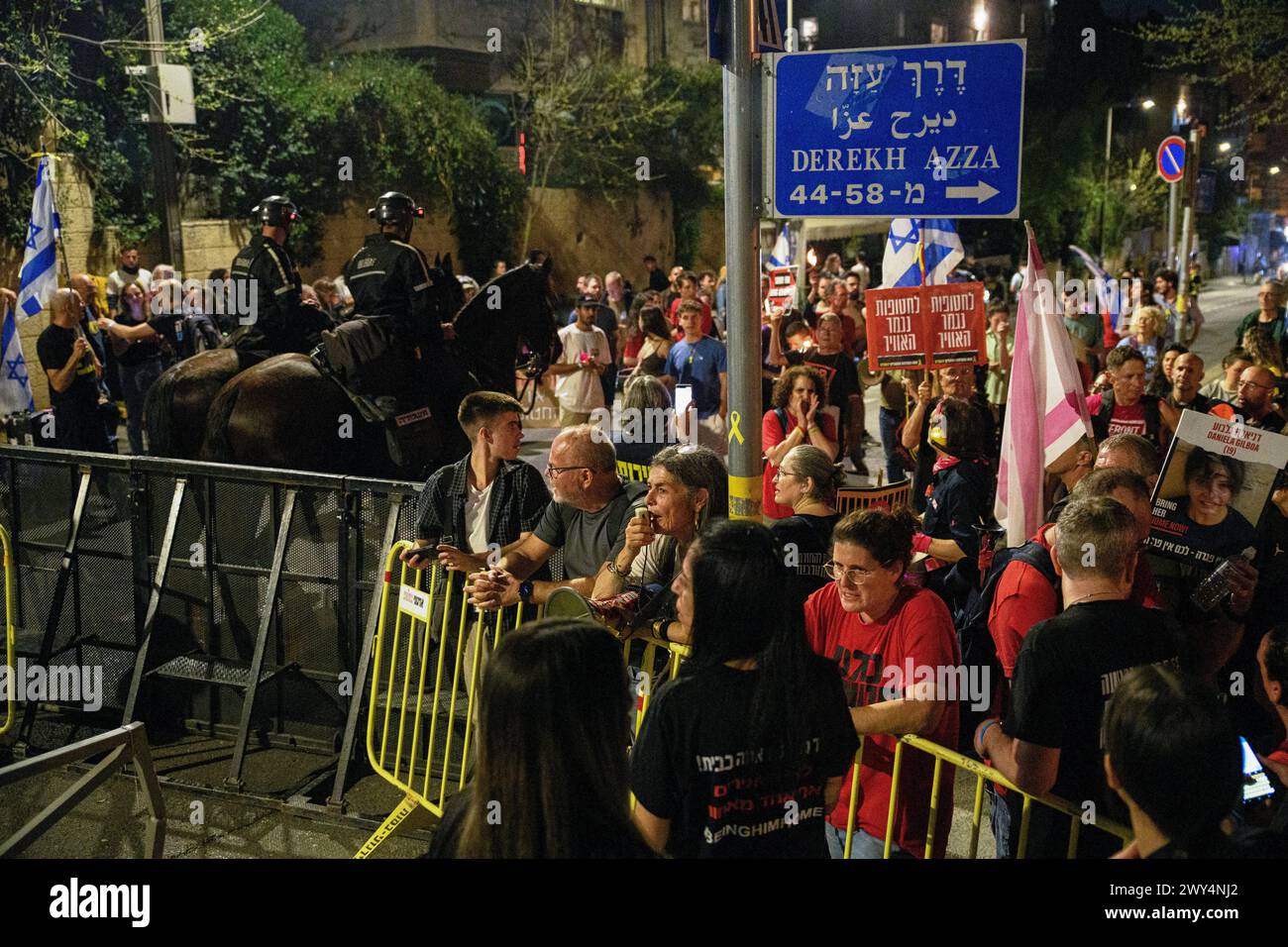 Israeli police officers stand in front of protestors next to PM ...