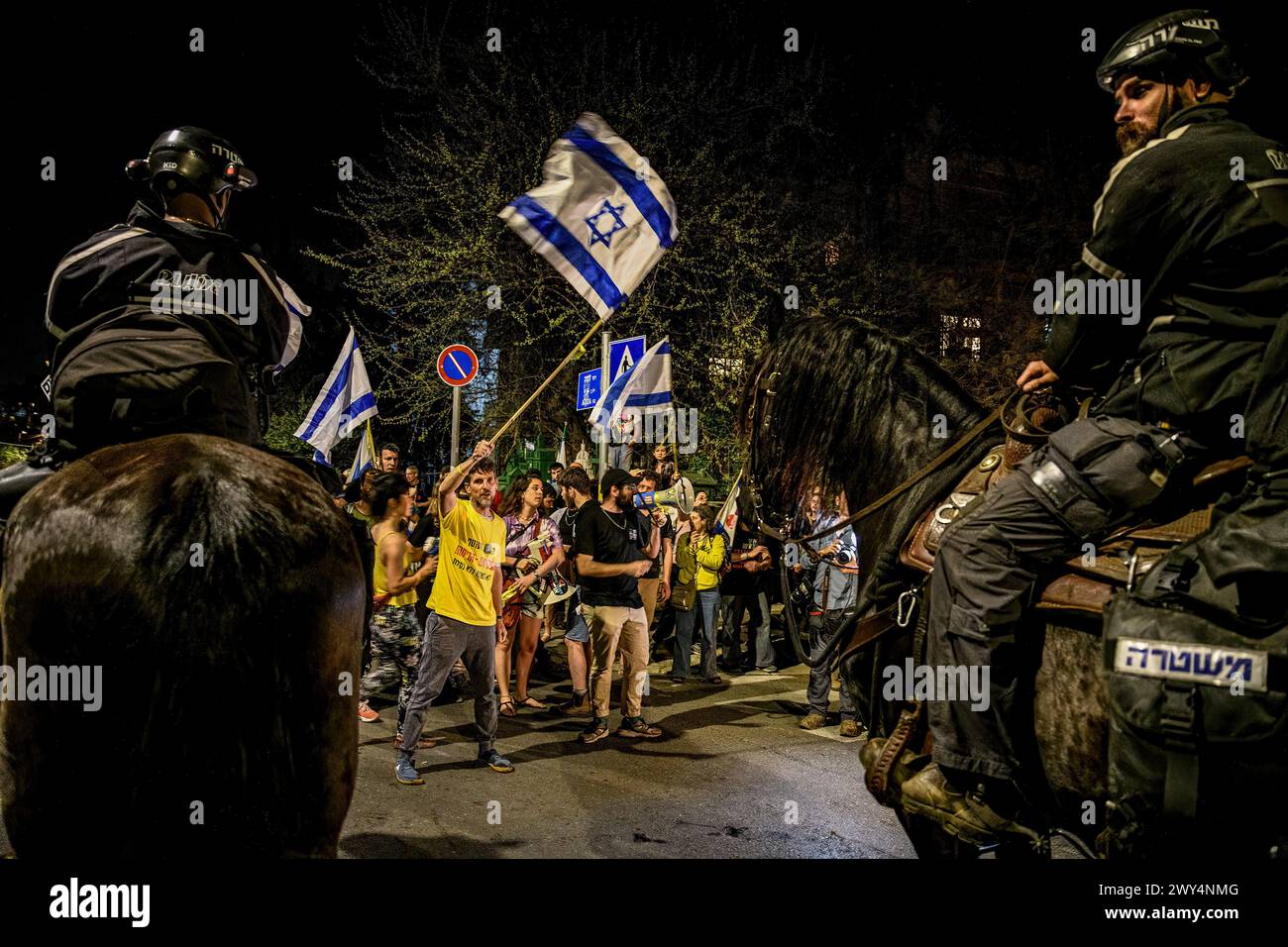 A protestor waves a flag in front of Israeli mounted police officers ...