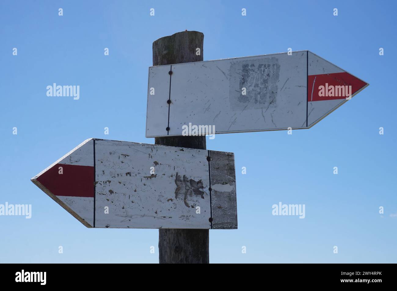Wooden signpost with two arrows and clear sky Stock Photo - Alamy