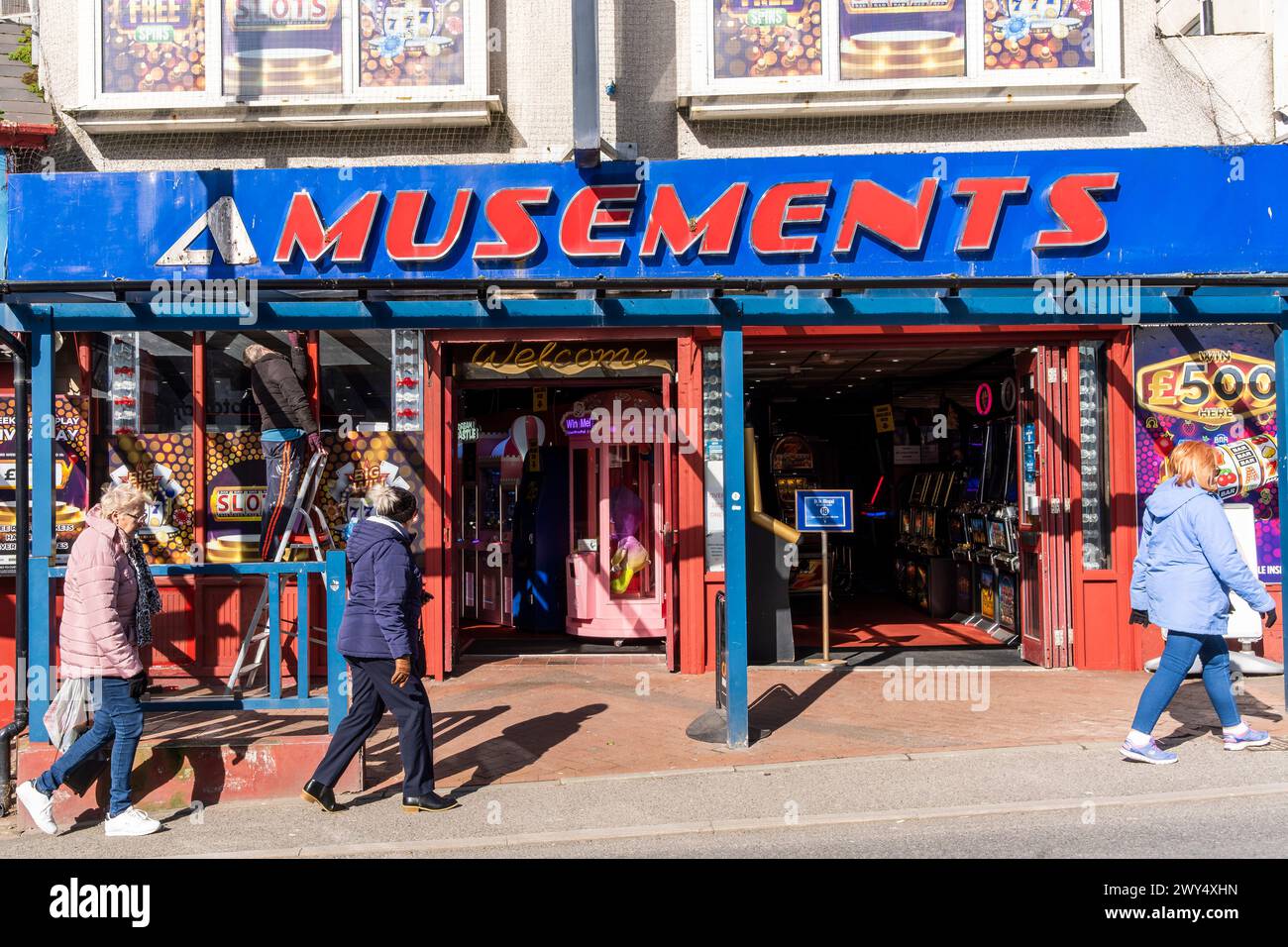 People Pedestrians walking past an amusement arcade in Newquay town ...