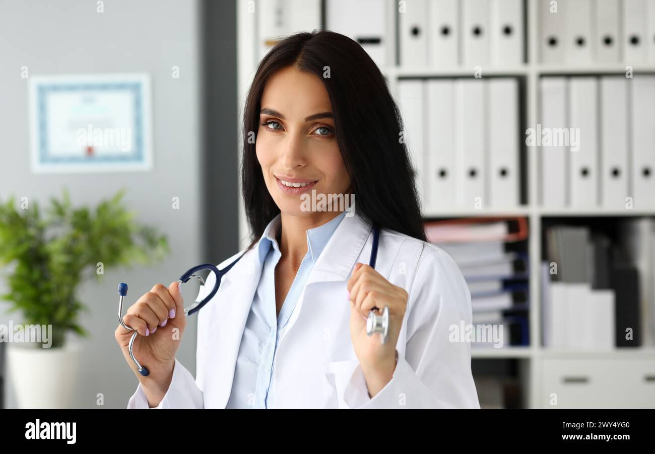 Pretty adult caucasian female GP stretching stethoscope in hands Stock ...