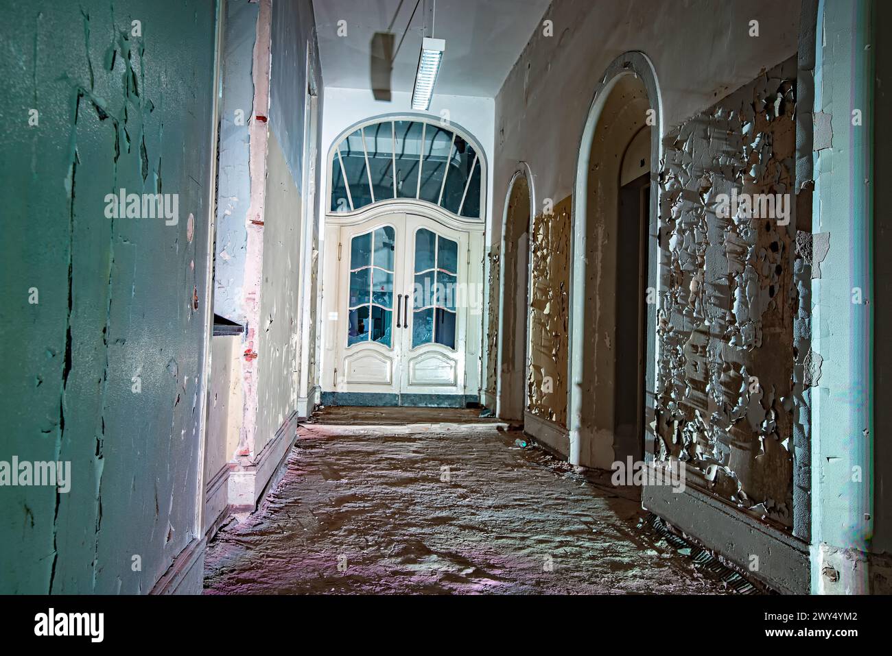 Interior of rundown building hallway with open door Stock Photo - Alamy