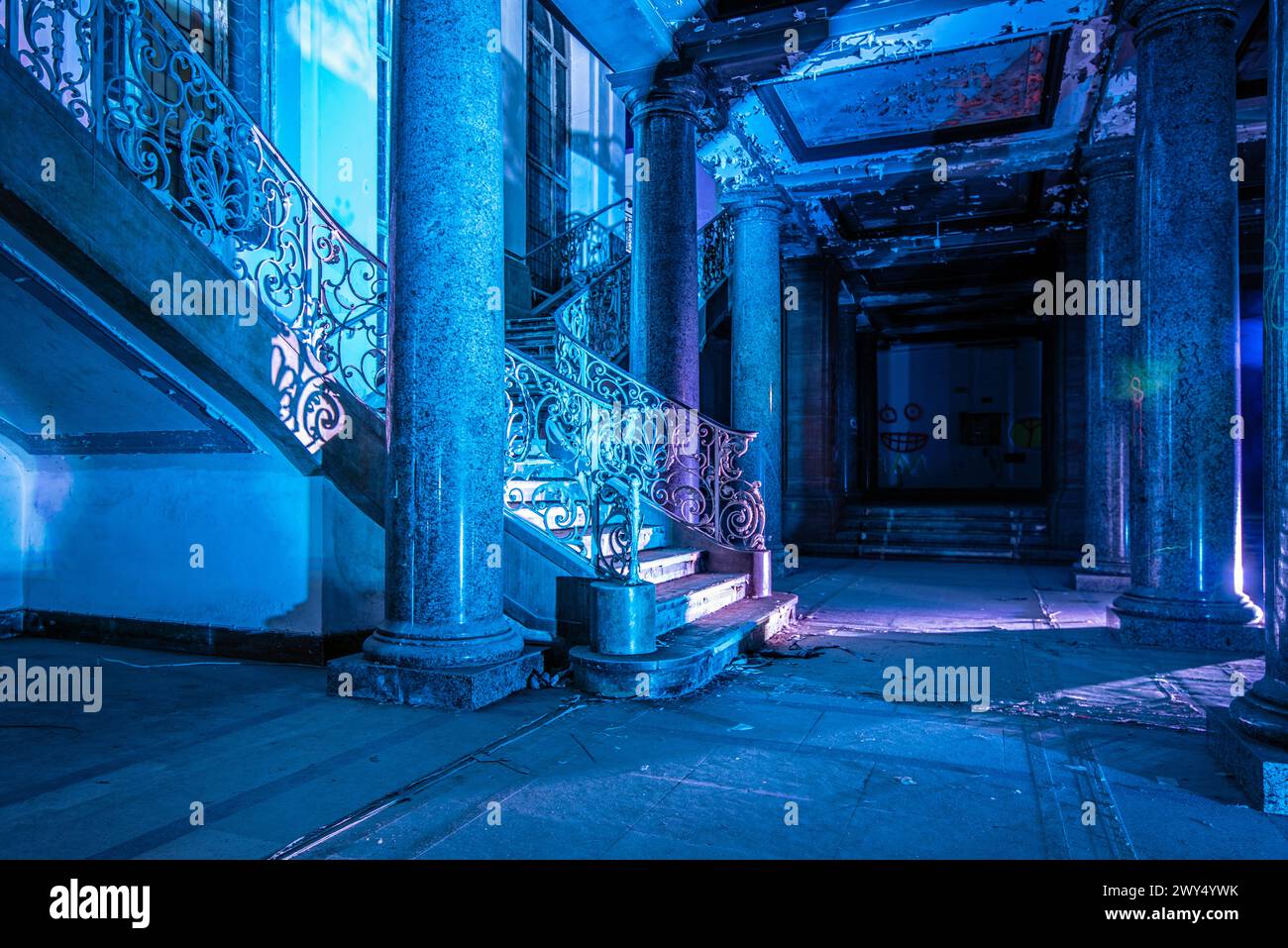 Blue-lit entrance to deserted building with decorative railings Stock ...