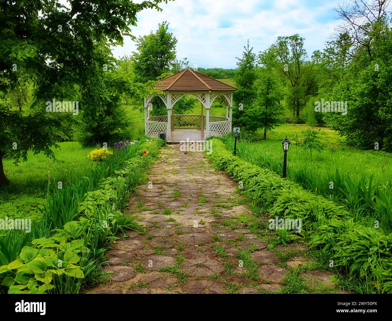 Garden wooden path to the gazebo. Green garden backyard decoration with ...