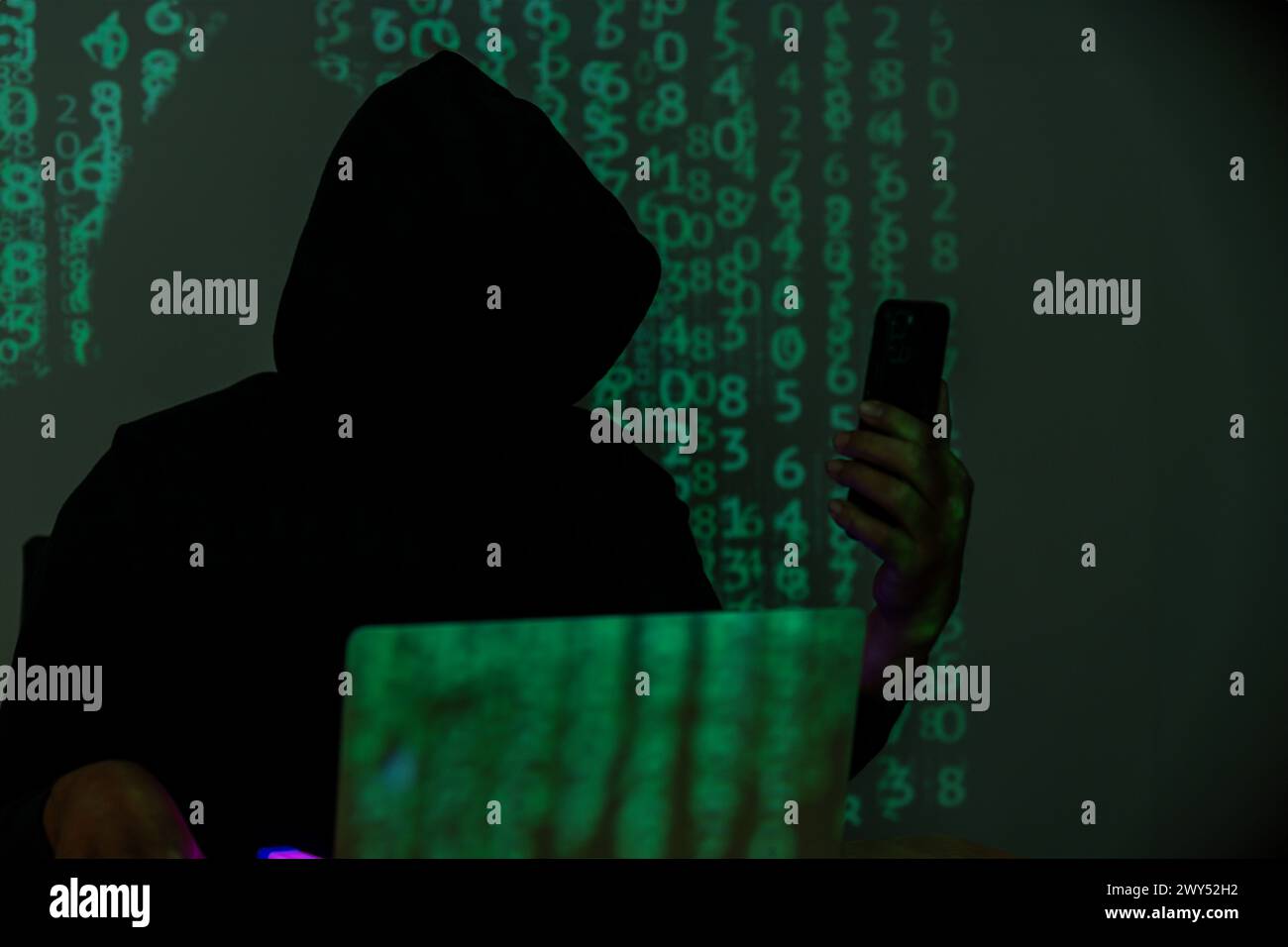 Hacker using cell phone for hacking Stock Photo - Alamy