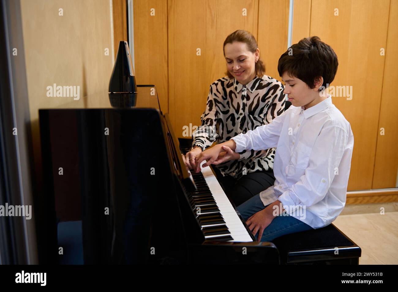 Authentic female music teacher explaining piano lesson to her student ...