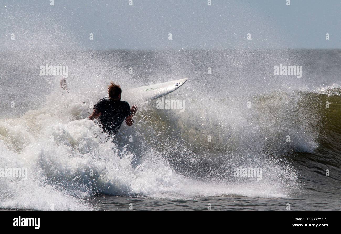 One male surfer wipingout and falling trying to surf on very rough ...