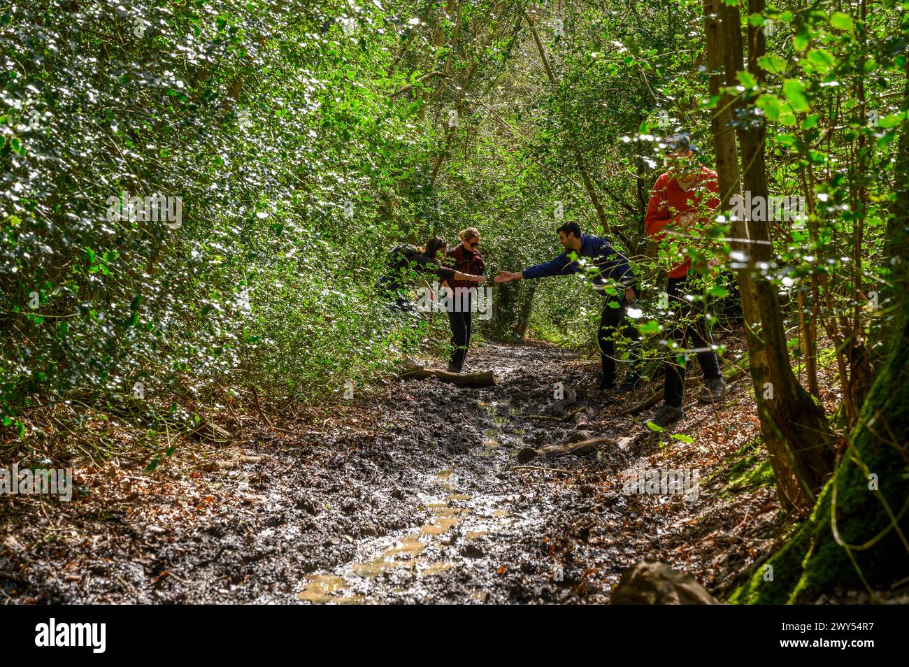 Young adults traversing an extremely muddy footpath between Haywards ...