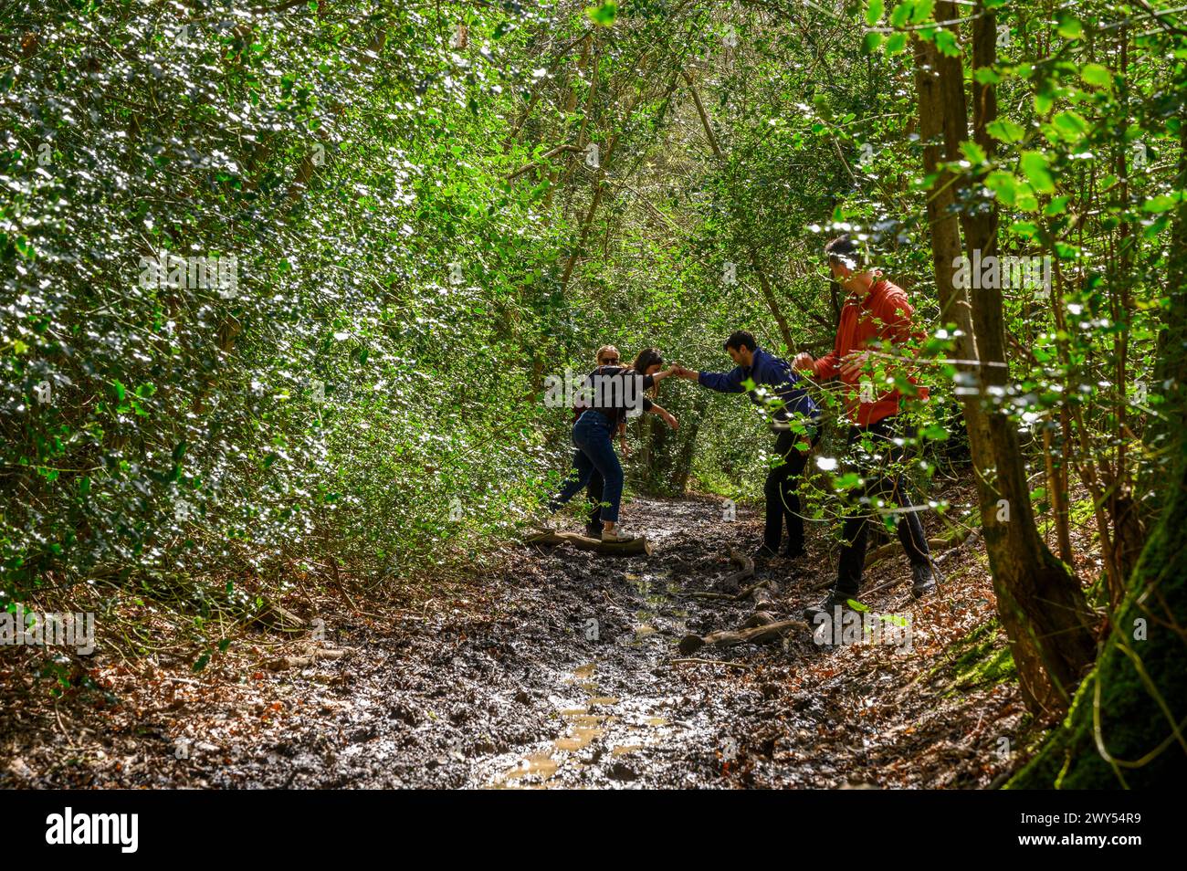 Young adults traversing an extremely muddy footpath between Haywards ... Young adults traversing an extremely muddy footpath between Haywards ...