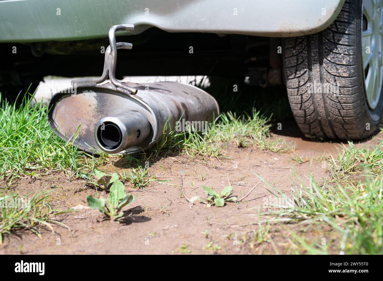 Broken exhaust and muffler of a car, rusted silencer fallen down on the ...