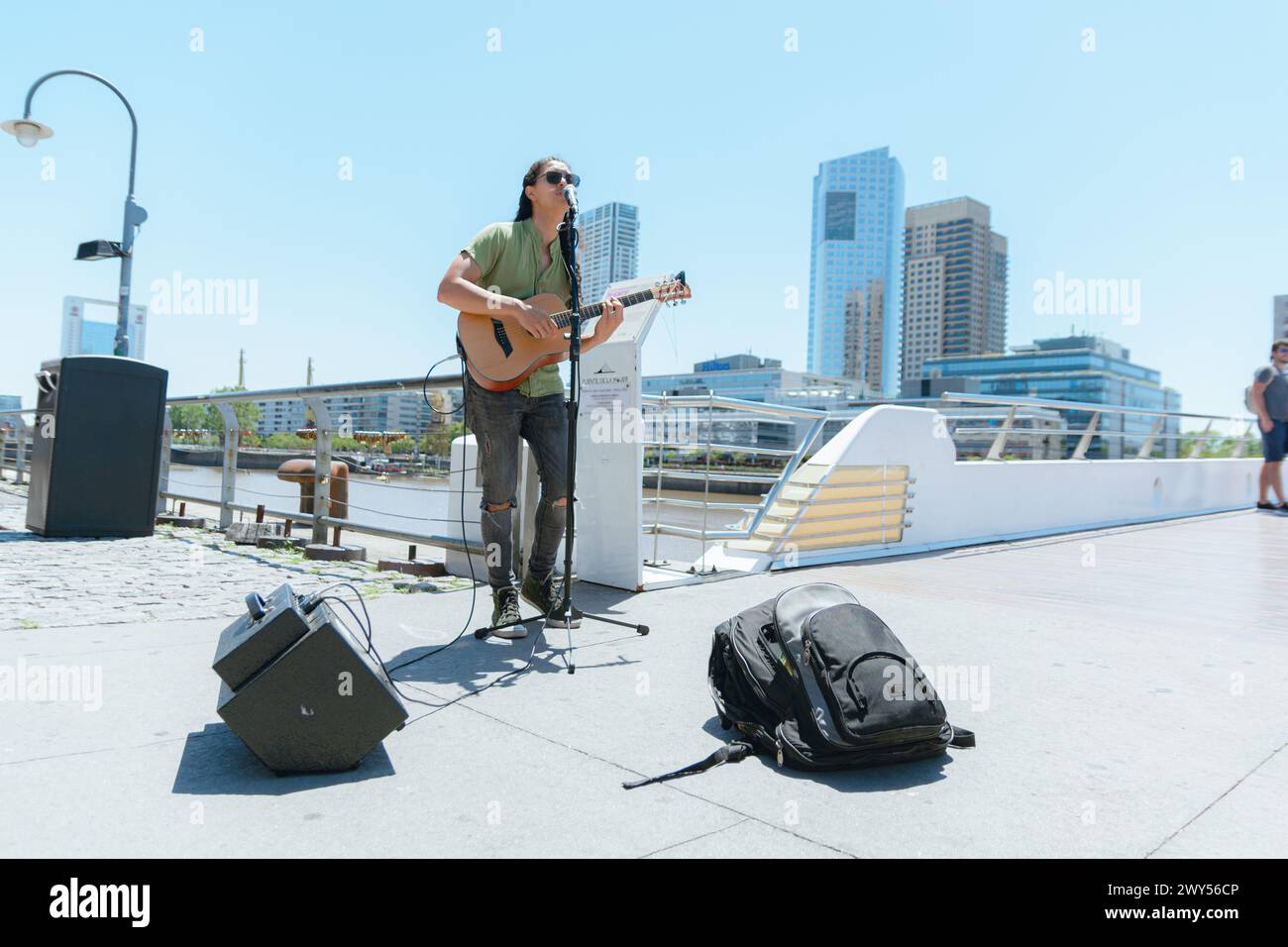 front view of young man with long dark hair with sunglasses busker ...