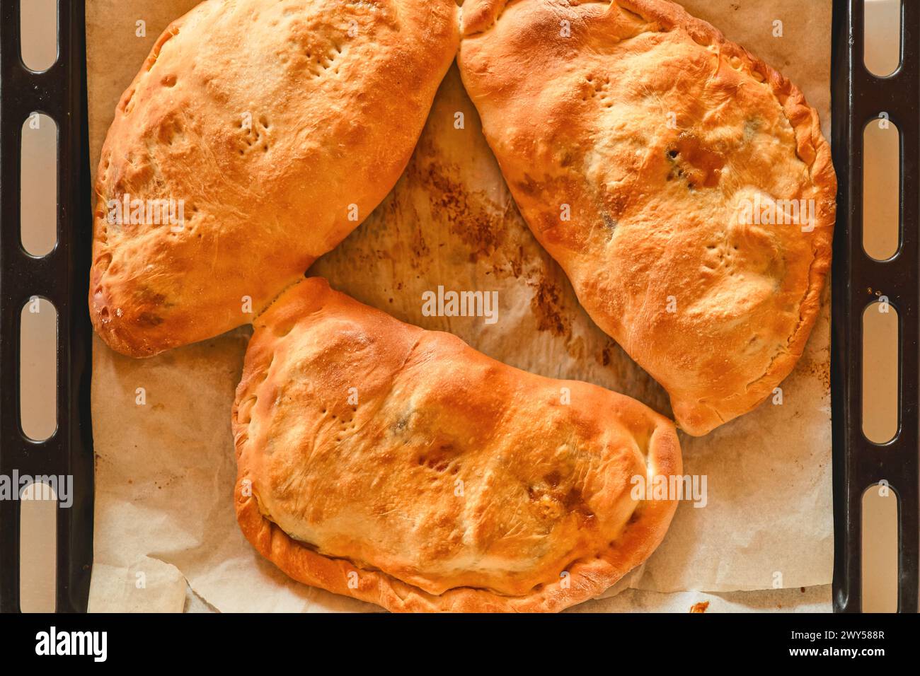 Homemade calzones cooling on a baking sheet, a delicious traditional ...