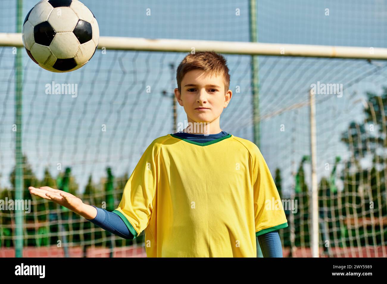 A young boy stands on a green soccer field, exuding excitement as he ...