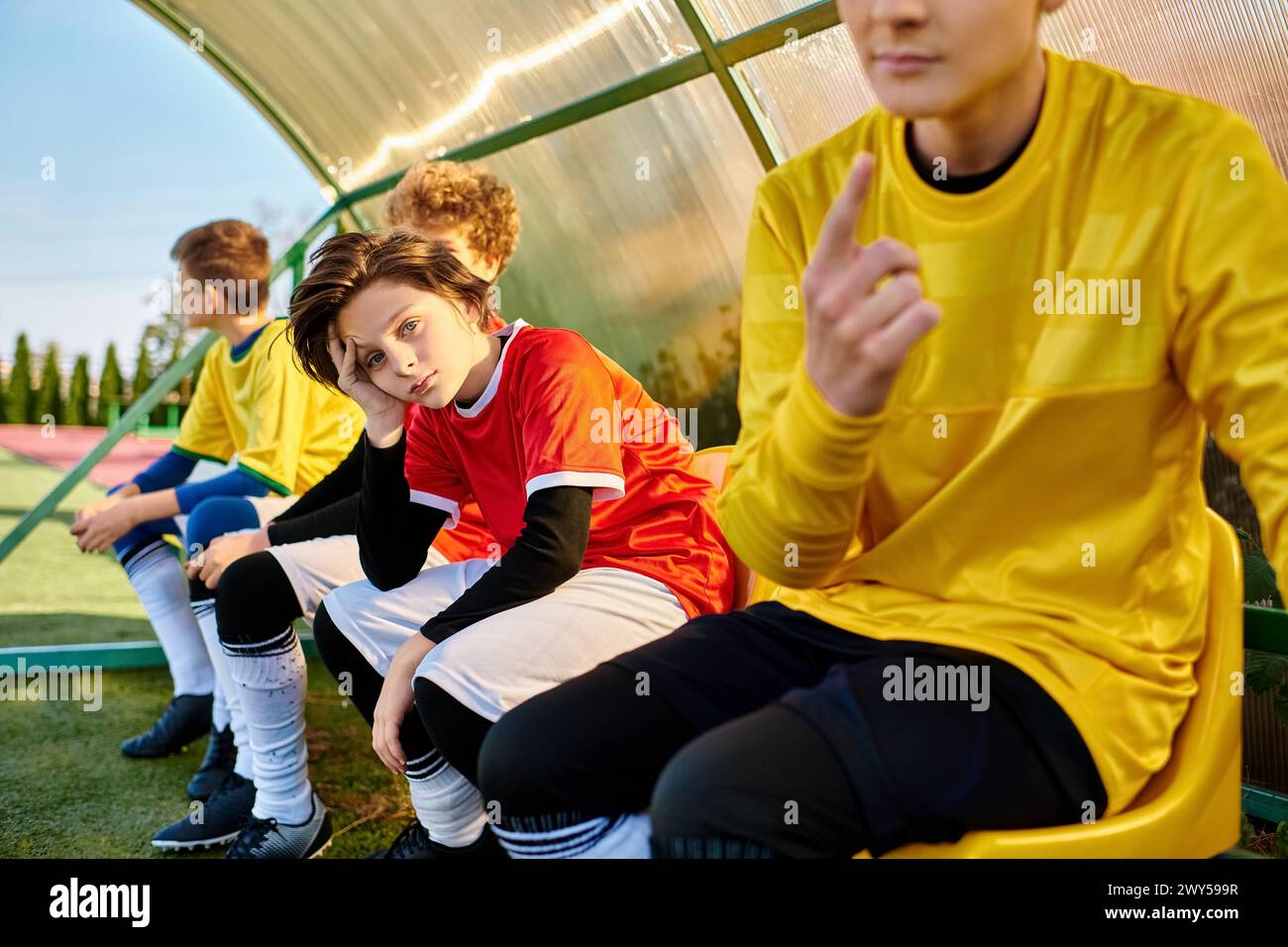 A diverse group of young individuals sitting closely together, engaged ...