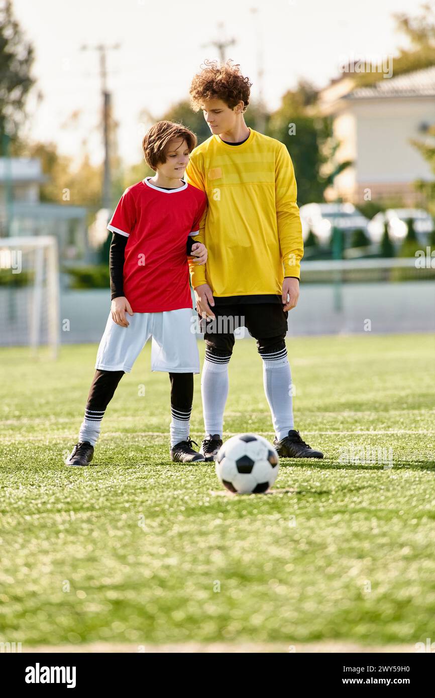 Two young men stand confidently on top of the soccer field, surveying ...