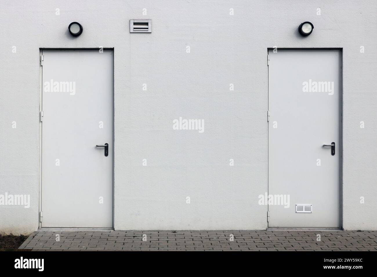 White wall with two closed doors Stock Photo - Alamy