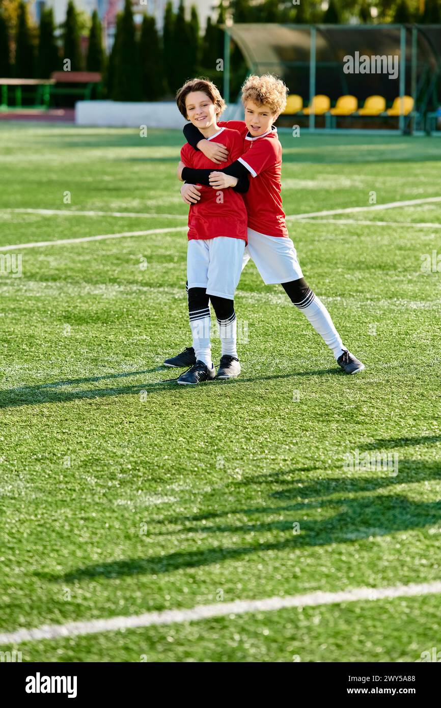 Two young boys, wearing soccer gear, lovingly hug each other on the ...