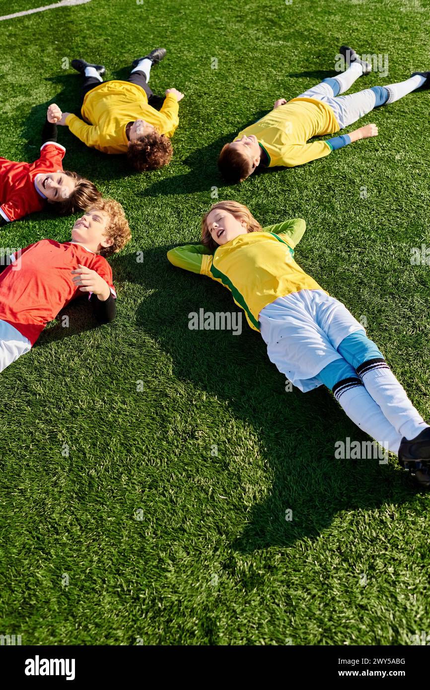 A group of young boys with various expressions are lying down on top of ...