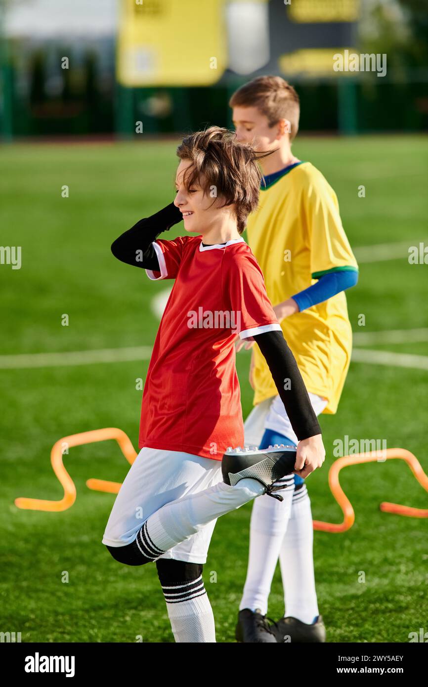 Two young men, energized and triumphant, stand atop the soccer field ...