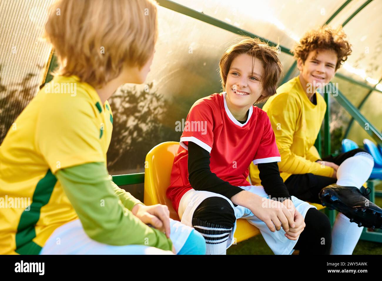 A group of young boys sit closely together, creating a circle of ...