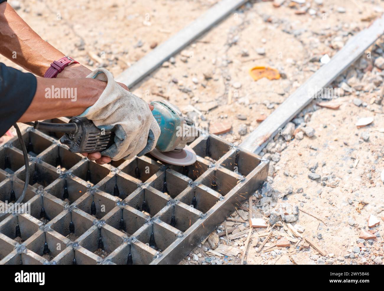 Worker cutting or grinding power tools for a finished metal grate ...