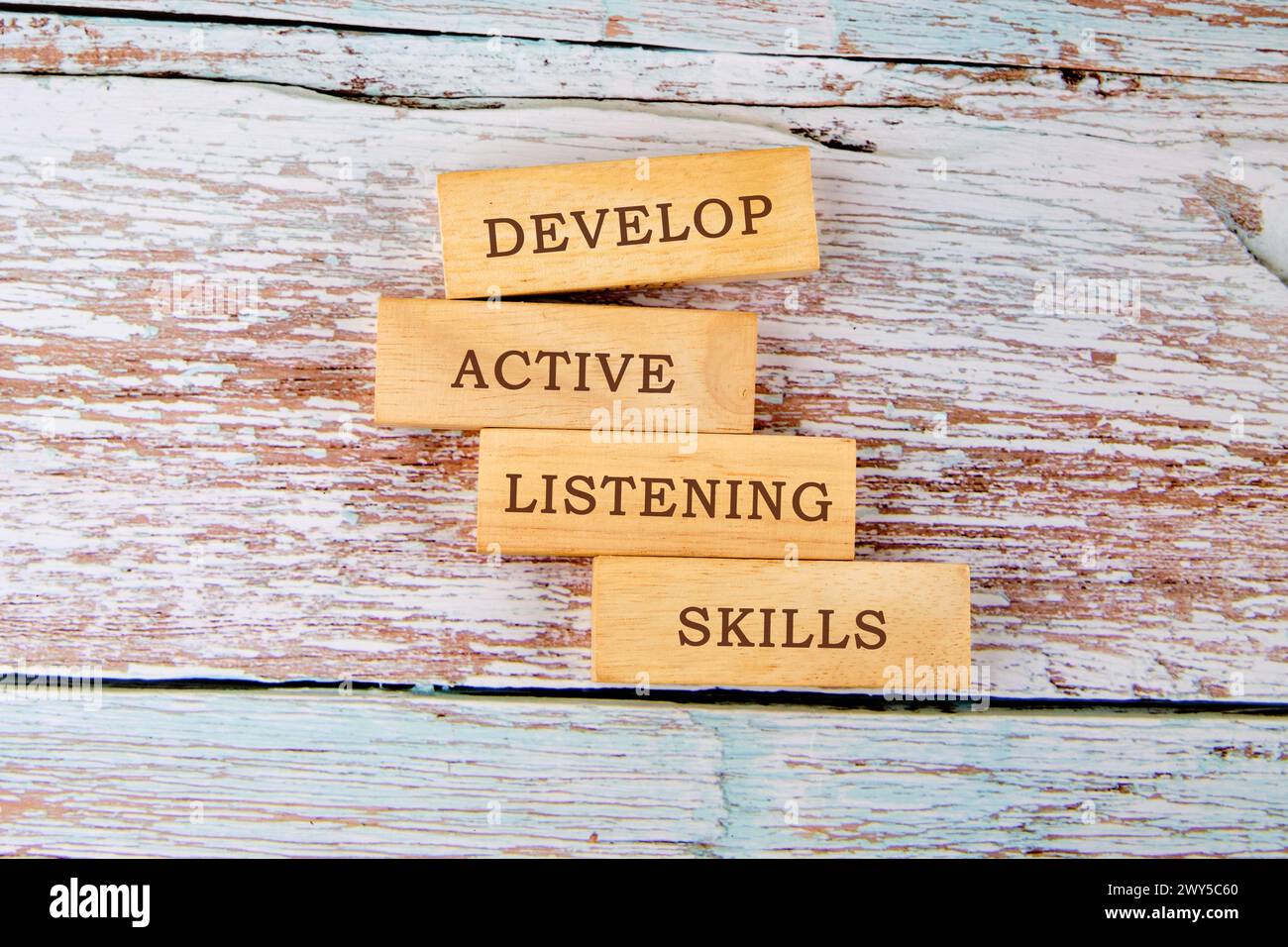Concept word Develop active listening skills on wooden blocks on old ...