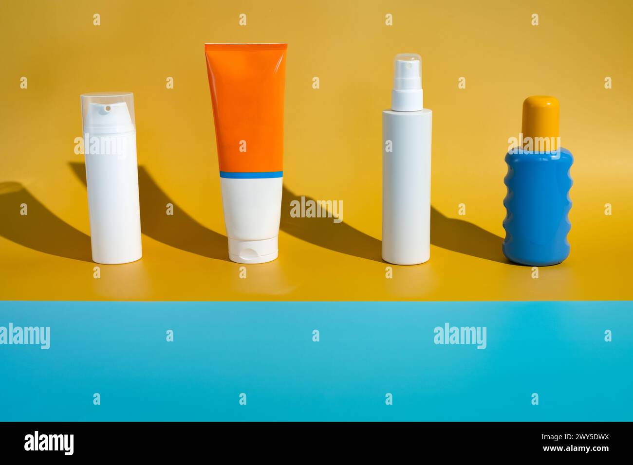 Different blank sunscreen packaging bottles on minimalist beach of ...