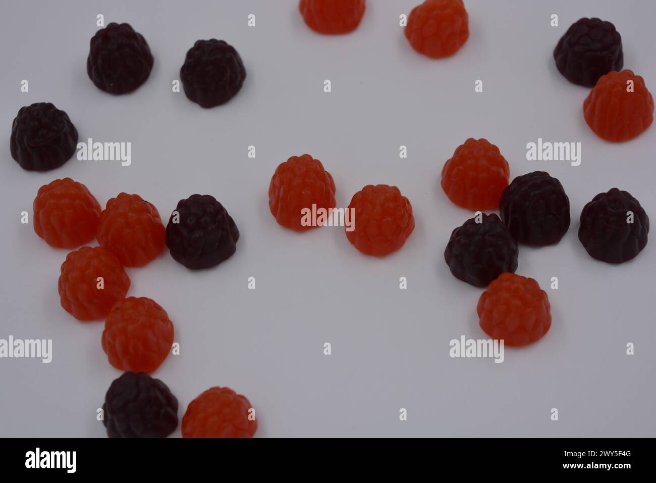 Unusual sweets, colored jelly candies in the form of fruits. Red, black ...