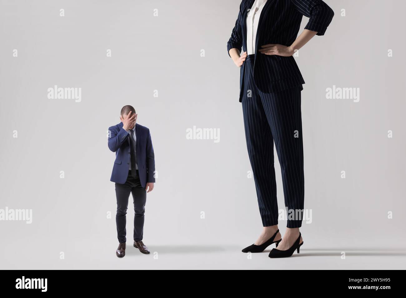 Giant woman and sad small man on light background Stock Photo - Alamy
