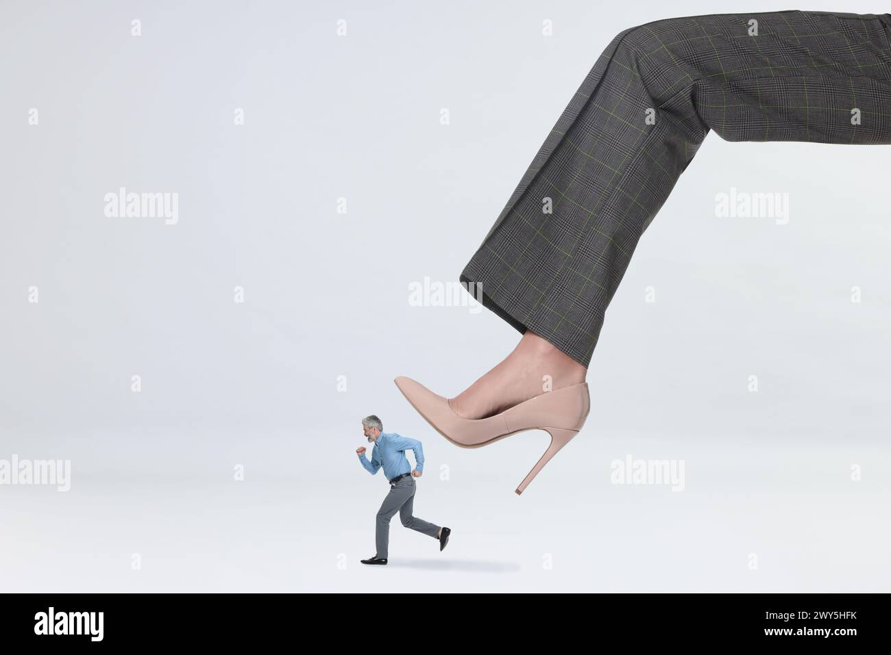 Big woman stepping onto small man on white background Stock Photo - Alamy