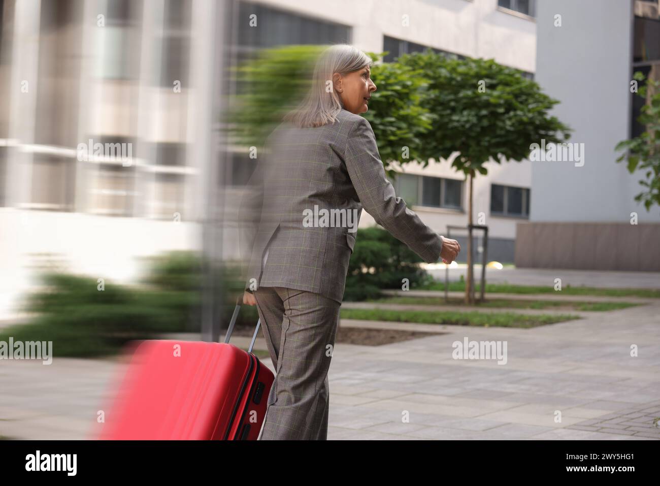 Being late. Woman with suitcase running on city street. Motion blur ...