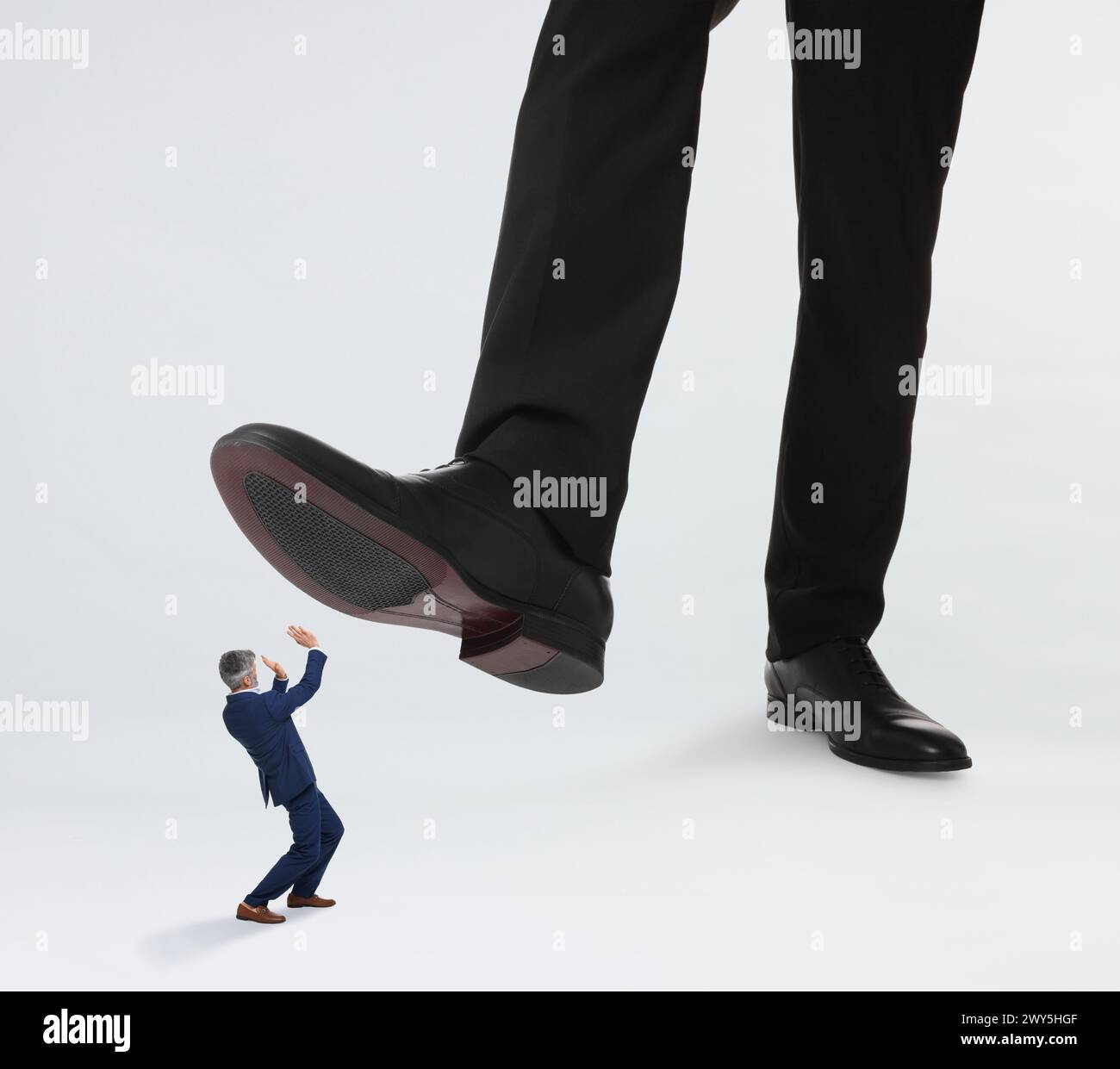 Giant stepping onto small man on white background Stock Photo - Alamy
