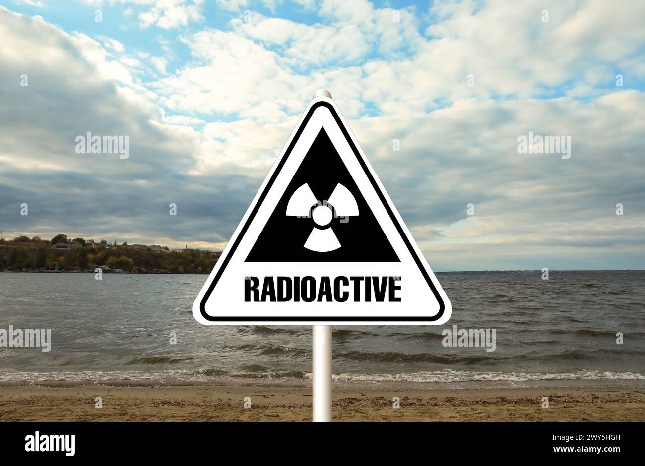 Radioactive pollution. Warning sign with hazard symbol near sea side ...