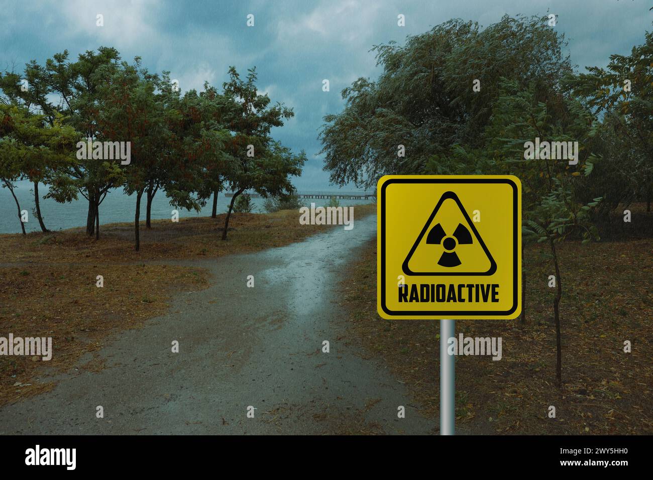 Radioactive pollution. Yellow warning sign with hazard symbol in rural ...