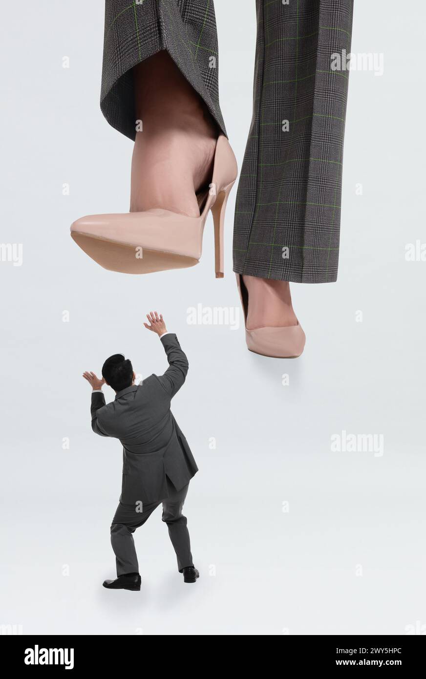 Big woman stepping onto small man on white background Stock Photo - Alamy