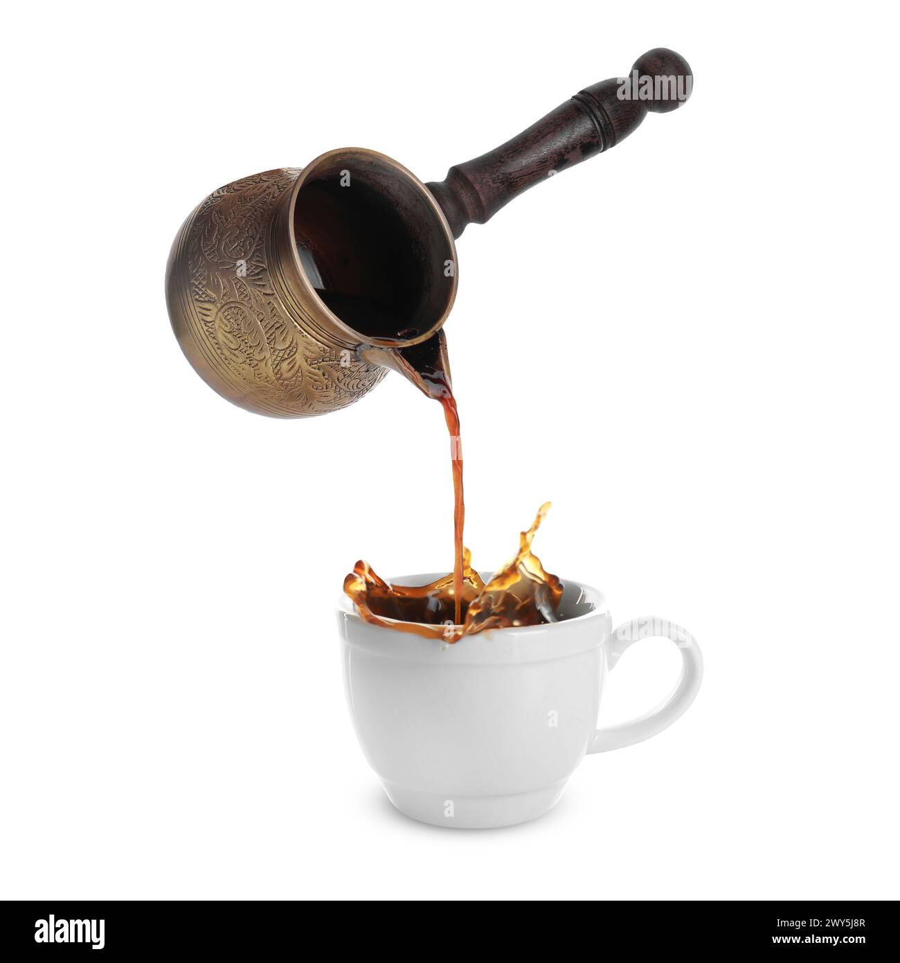 Pouring freshly brewed aromatic coffee from turkish pot into cup ...