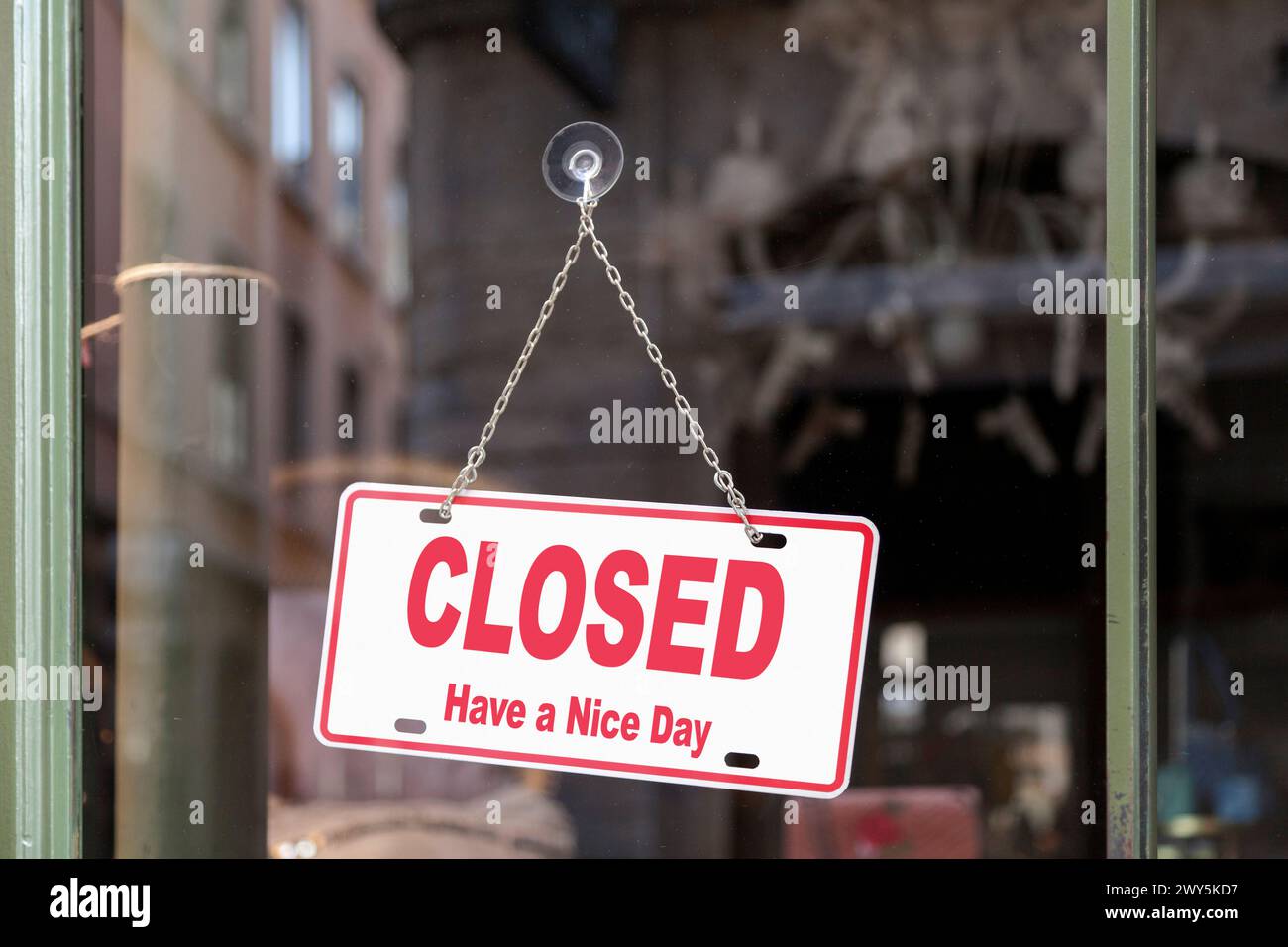 Close-up on a red sign in a window with written in it "Closed, have a ...