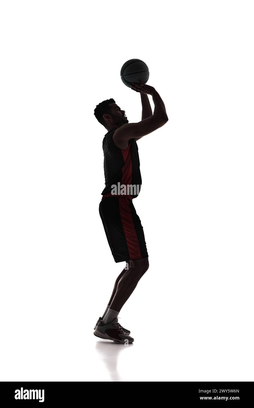 Full-length of young concentrated man, basketball player standing and ...
