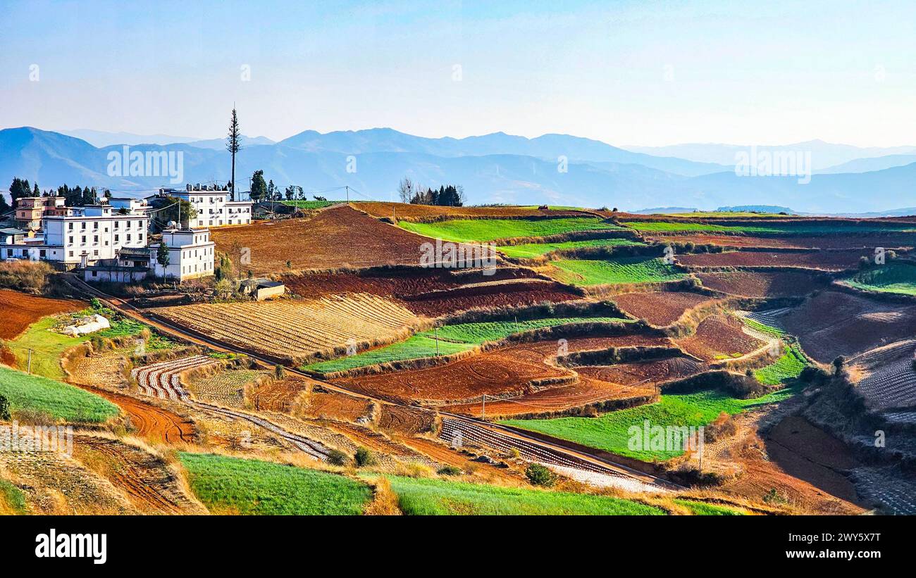 A scenic rural village with farms and a building on a mountainside in ...