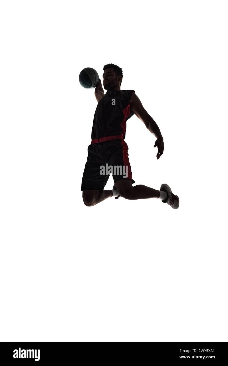 Slam dunk. Silhouette of young man, basketball player in motion during ...