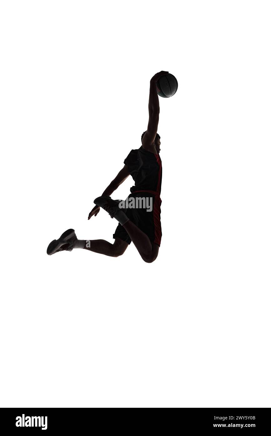Slam dunk. Back view silhouette of young man, basketball player in ...