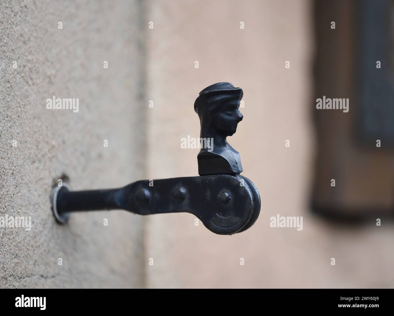 Antique handcrafted metal shutter dog on the exterior of a rural house ...
