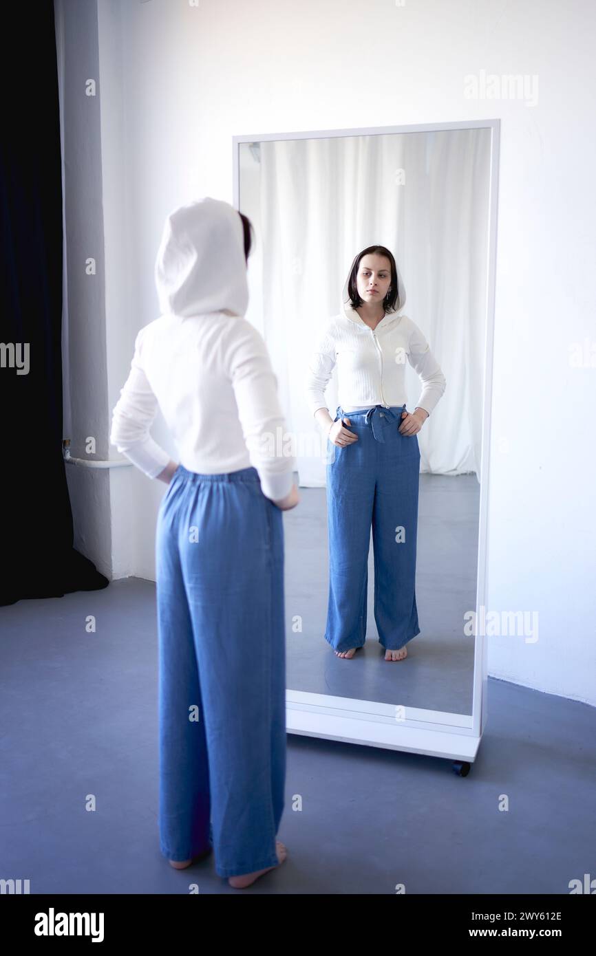 a young teenage girl battling brain cancer looks at her reflection in ...